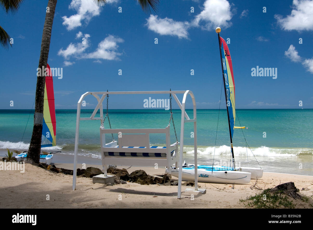 A Caribbean beach side seat with boats and ocean view Stock Photo - Alamy