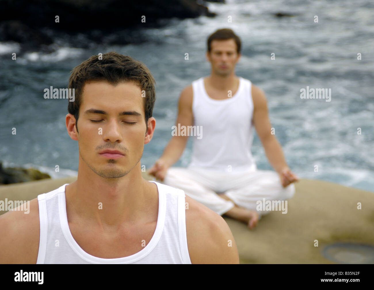 Two young men practicing yoga Stock Photo - Alamy