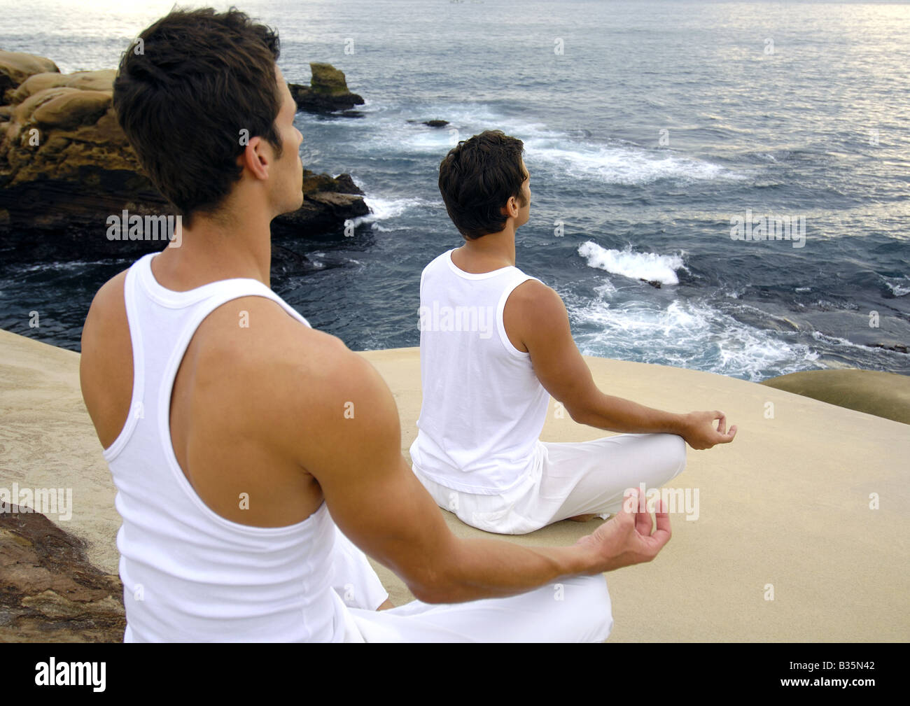 Rear view of two young men practicing yoga Stock Photo - Alamy