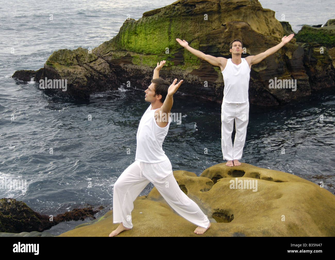 Two young men practicing yoga Stock Photo - Alamy