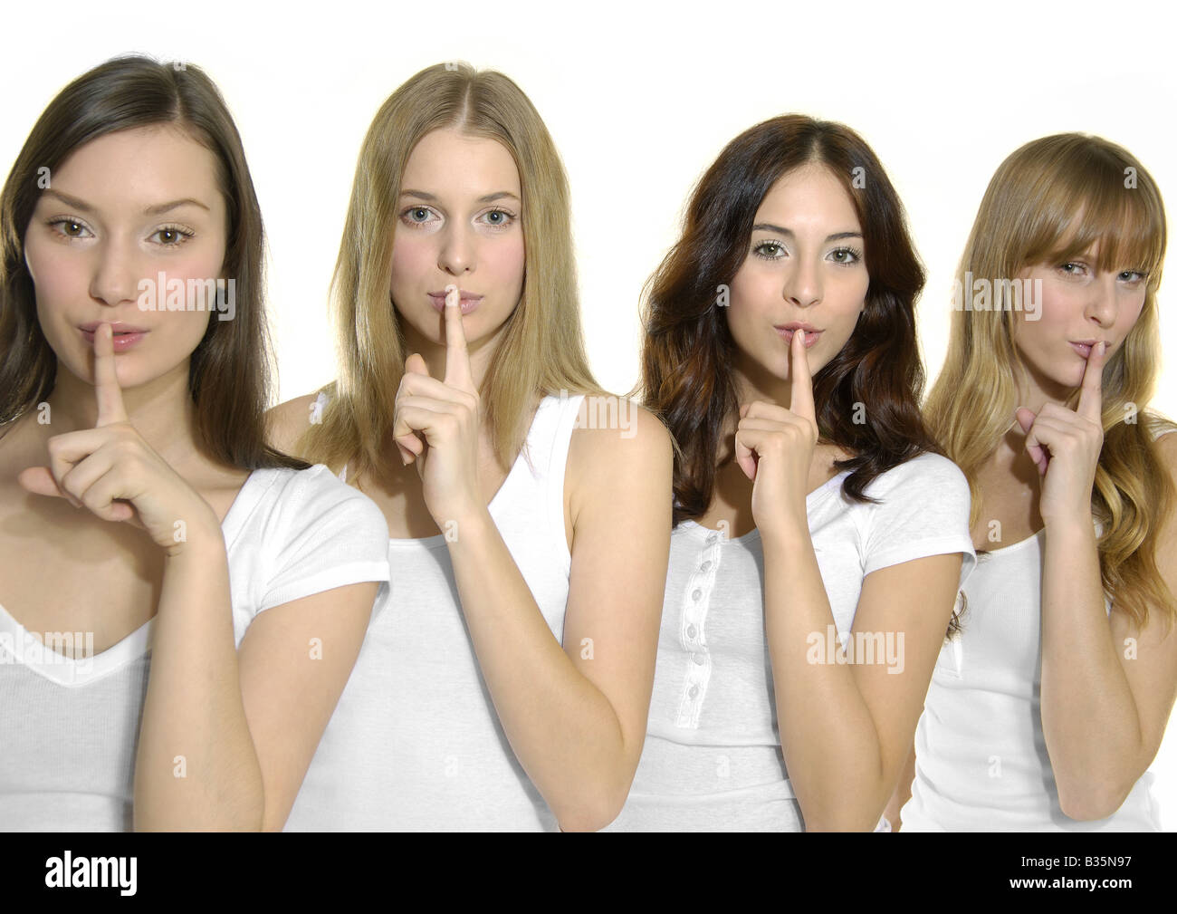 Portrait of four young women with their fingers on their lips Stock ...