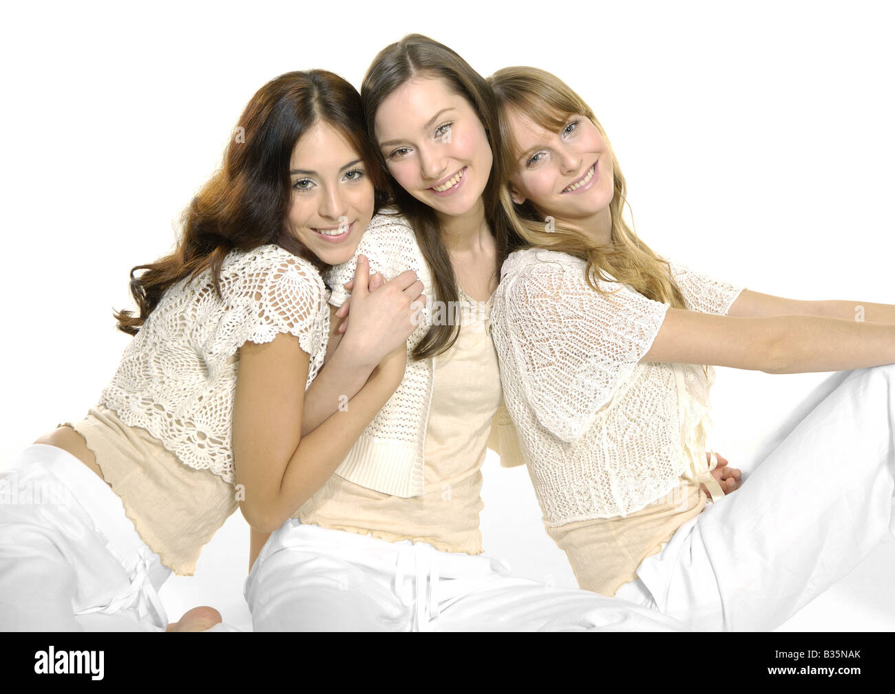 Portrait of three young women sitting together and smiling Stock Photo ...