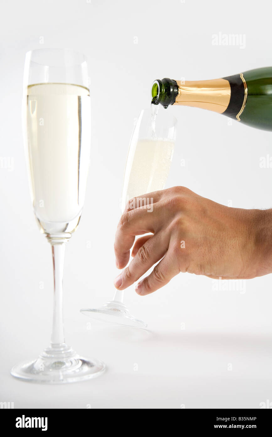Hand pouring champagne into glasses, close-up Stock Photo - Alamy