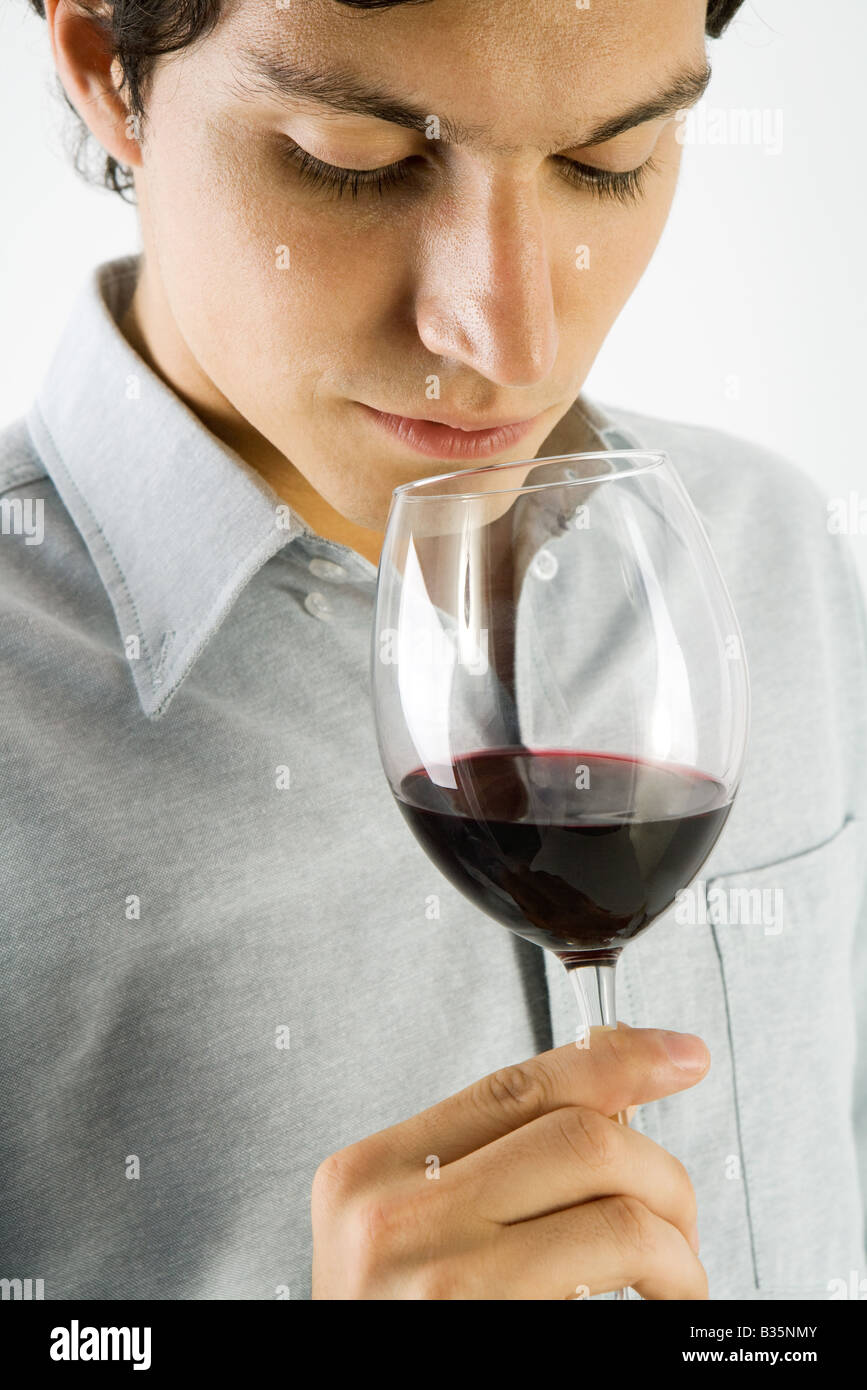 Man examining glass of red wine, close-up Stock Photo - Alamy
