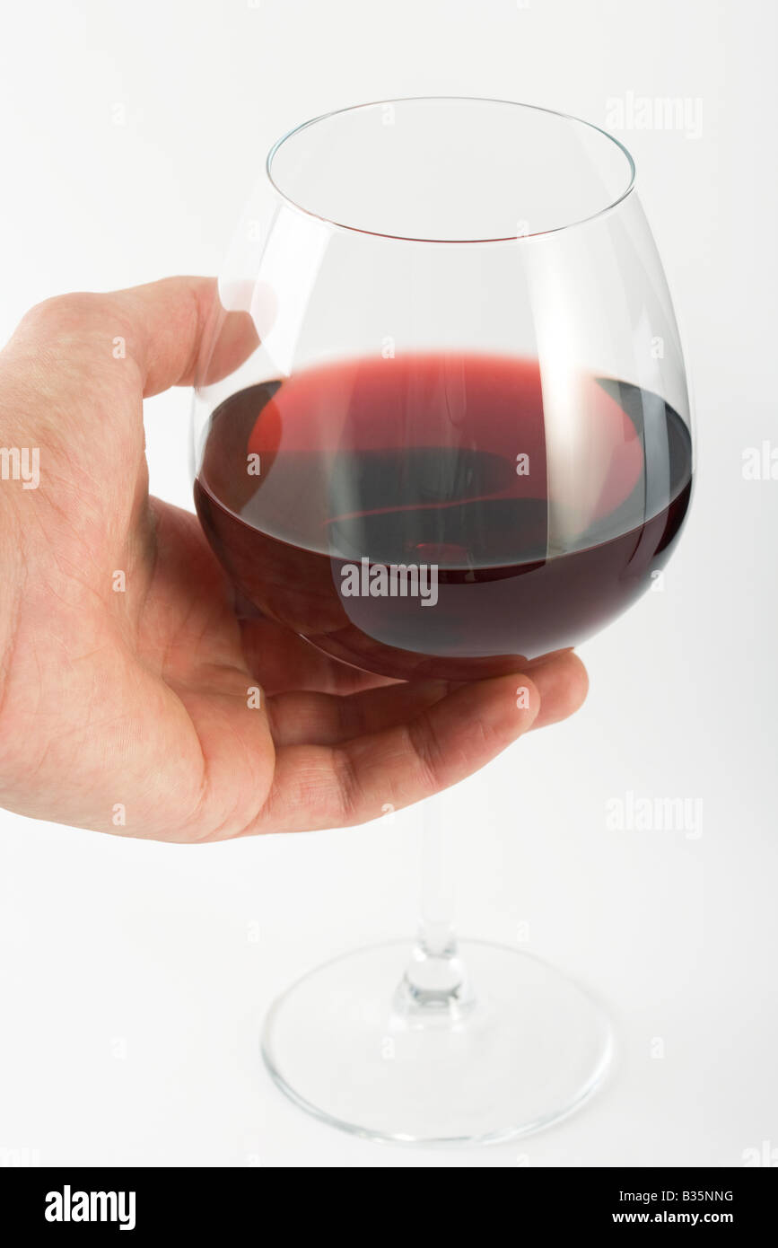 Hand holding glass of red wine Stock Photo - Alamy
