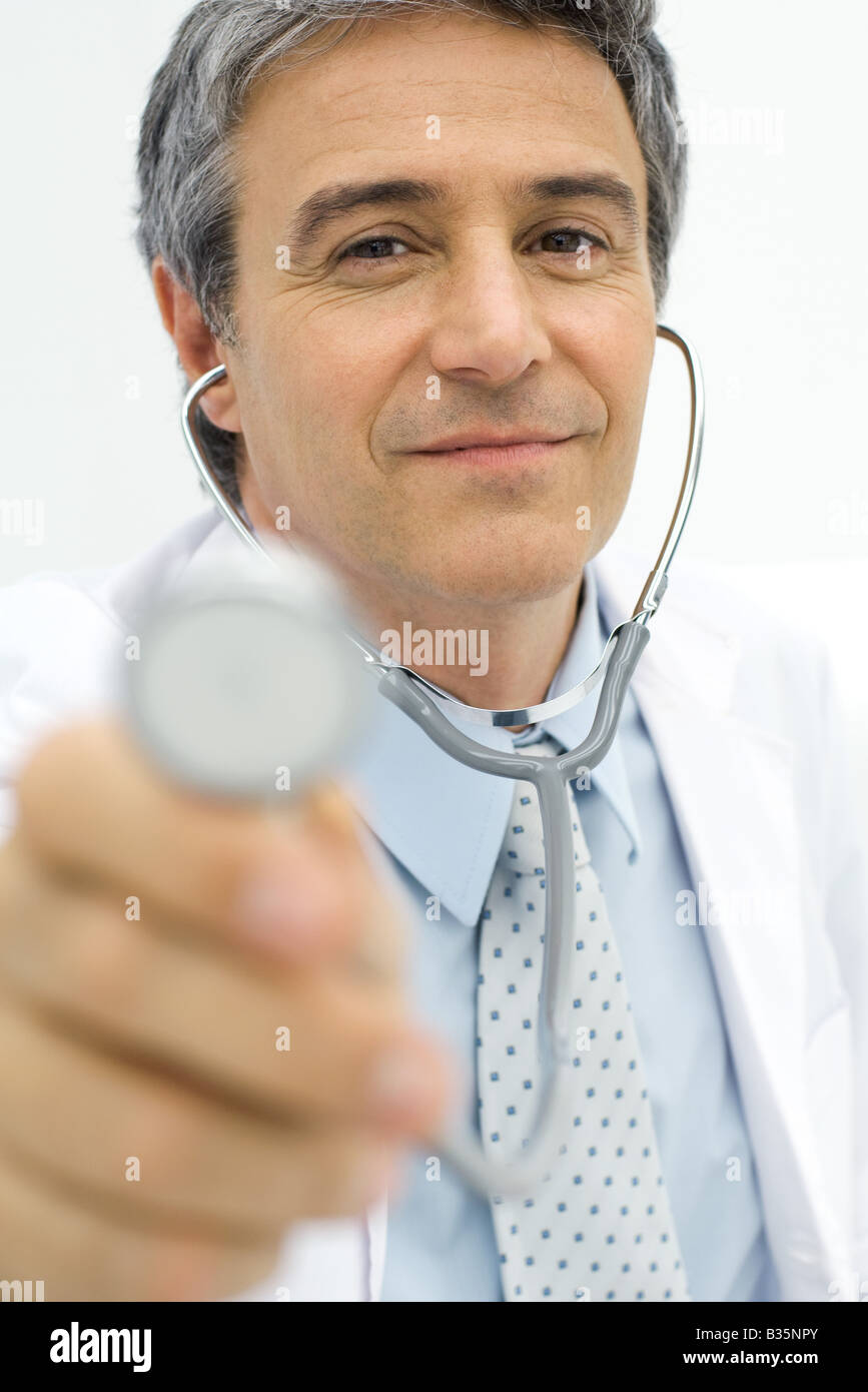 Doctor holding stethoscope toward camera, focus on background Stock ...