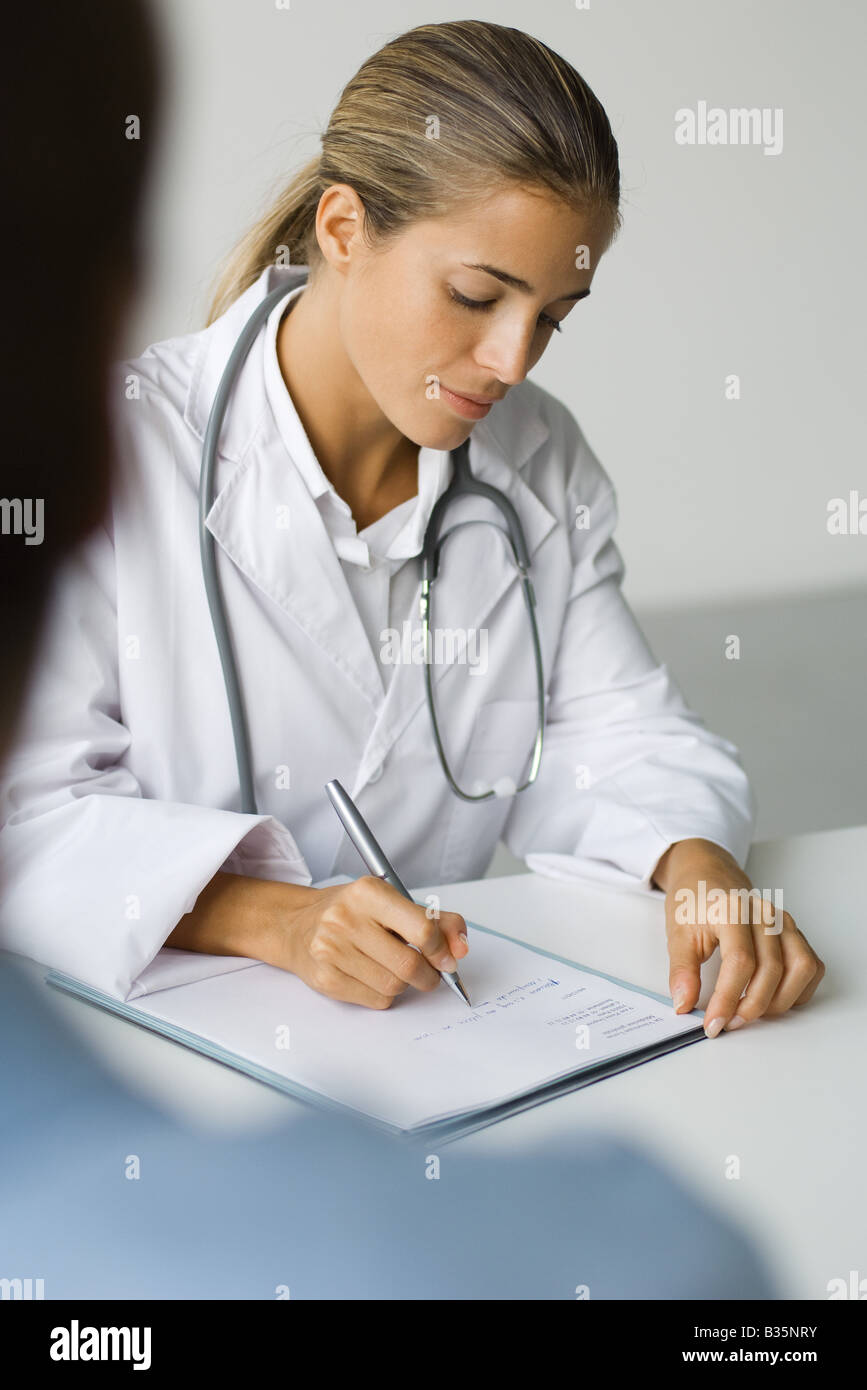 Doctor writes in patients medical hi-res stock photography and images ...
