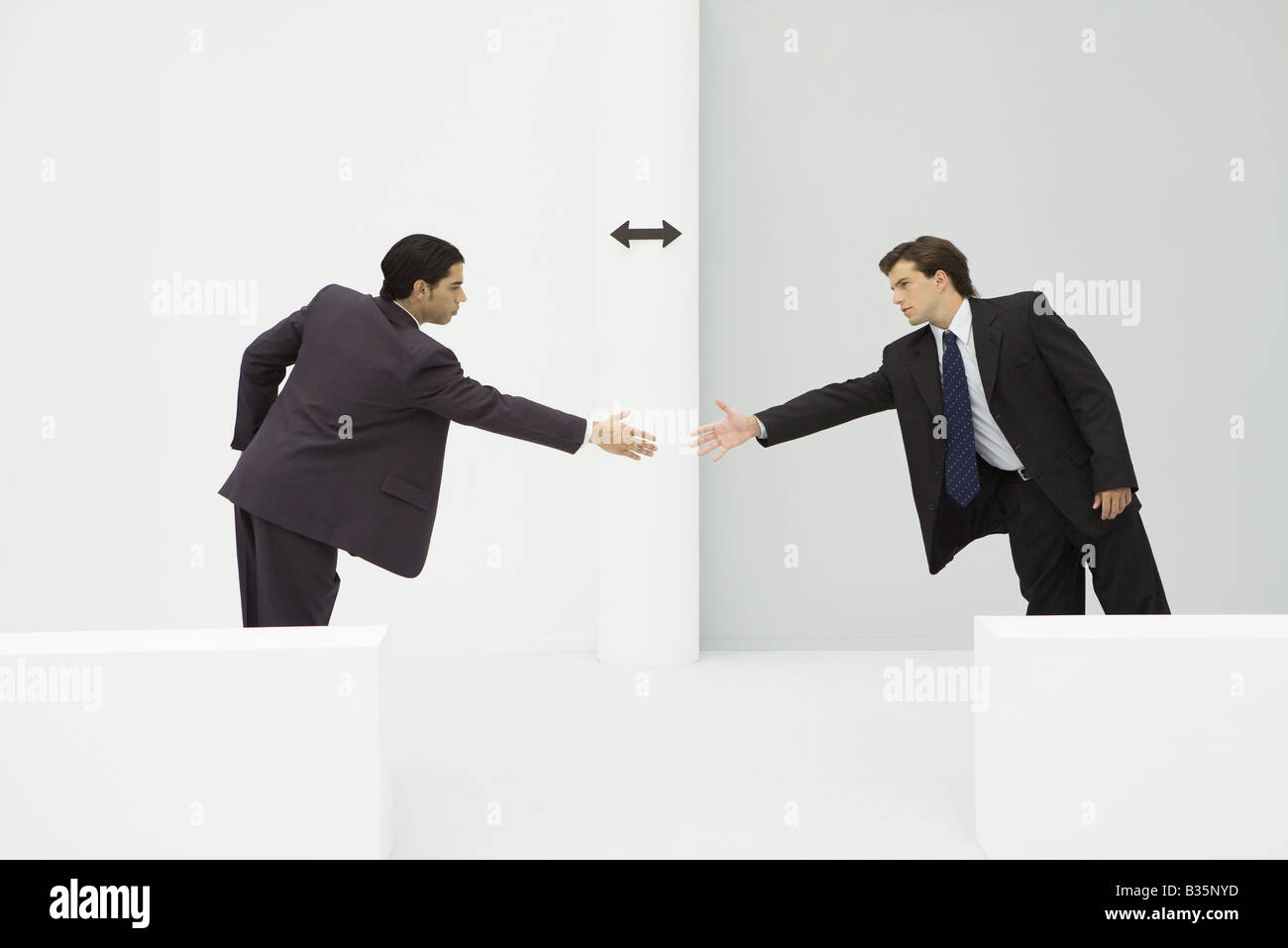 Two businessmen reaching to shake hands, arrow between them Stock Photo ...