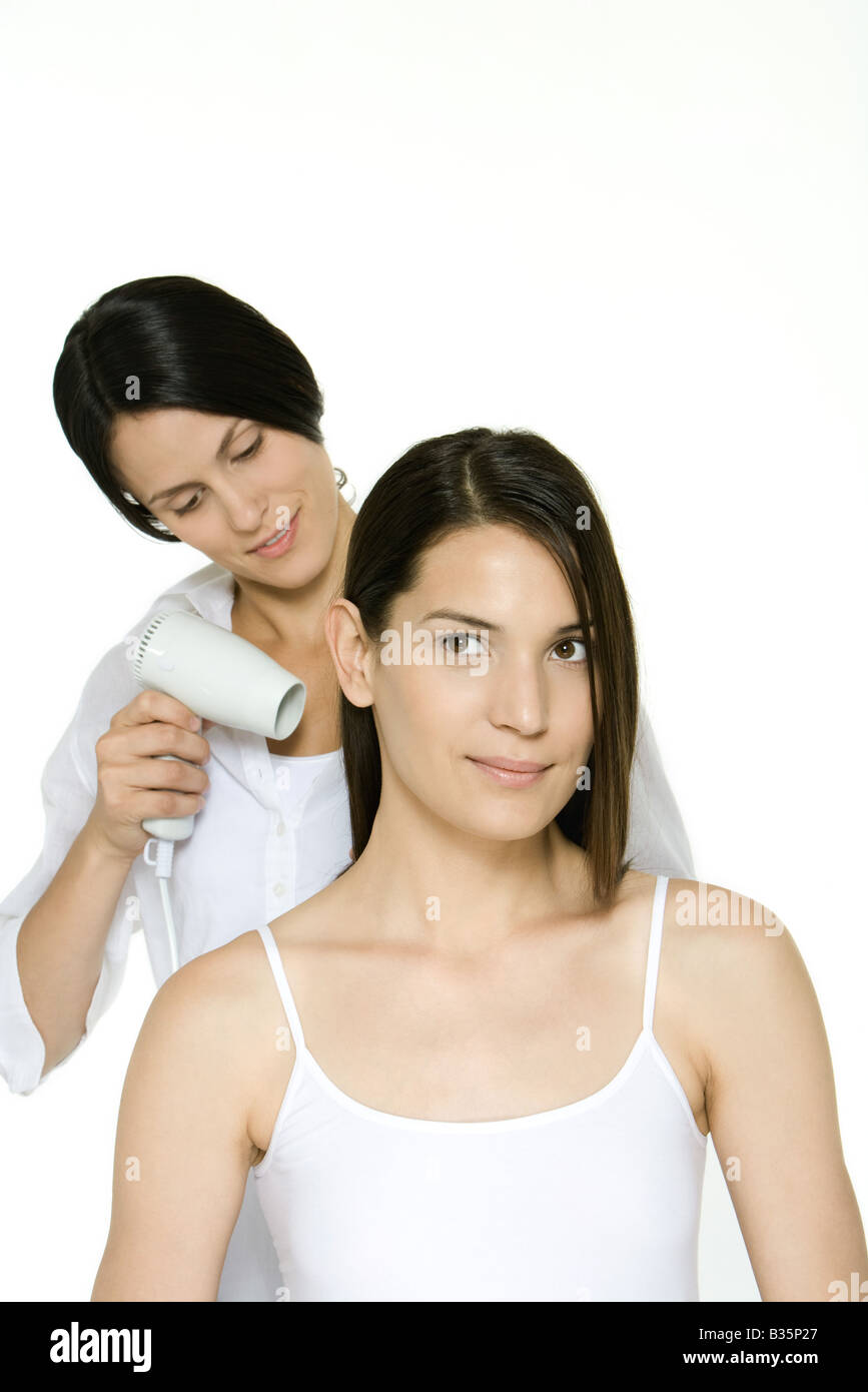 Hair stylist blow drying a woman's hair Stock Photo - Alamy