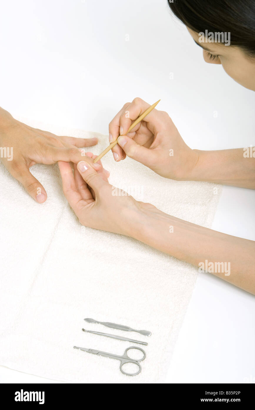 Woman using a cuticle pusher to give a manicure Stock Photo - Alamy