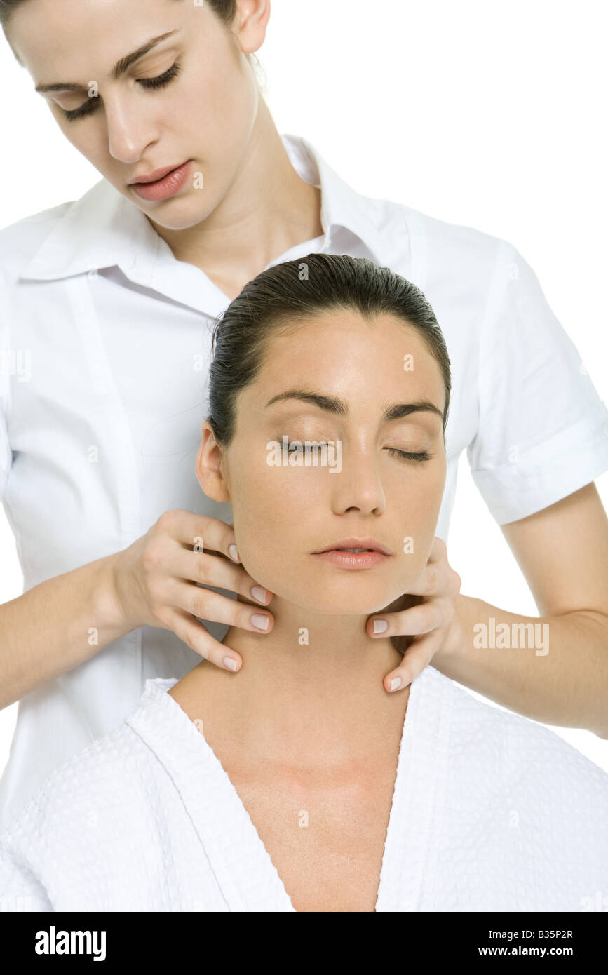 Massage therapist giving woman neck massage, eyes closed Stock Photo ...