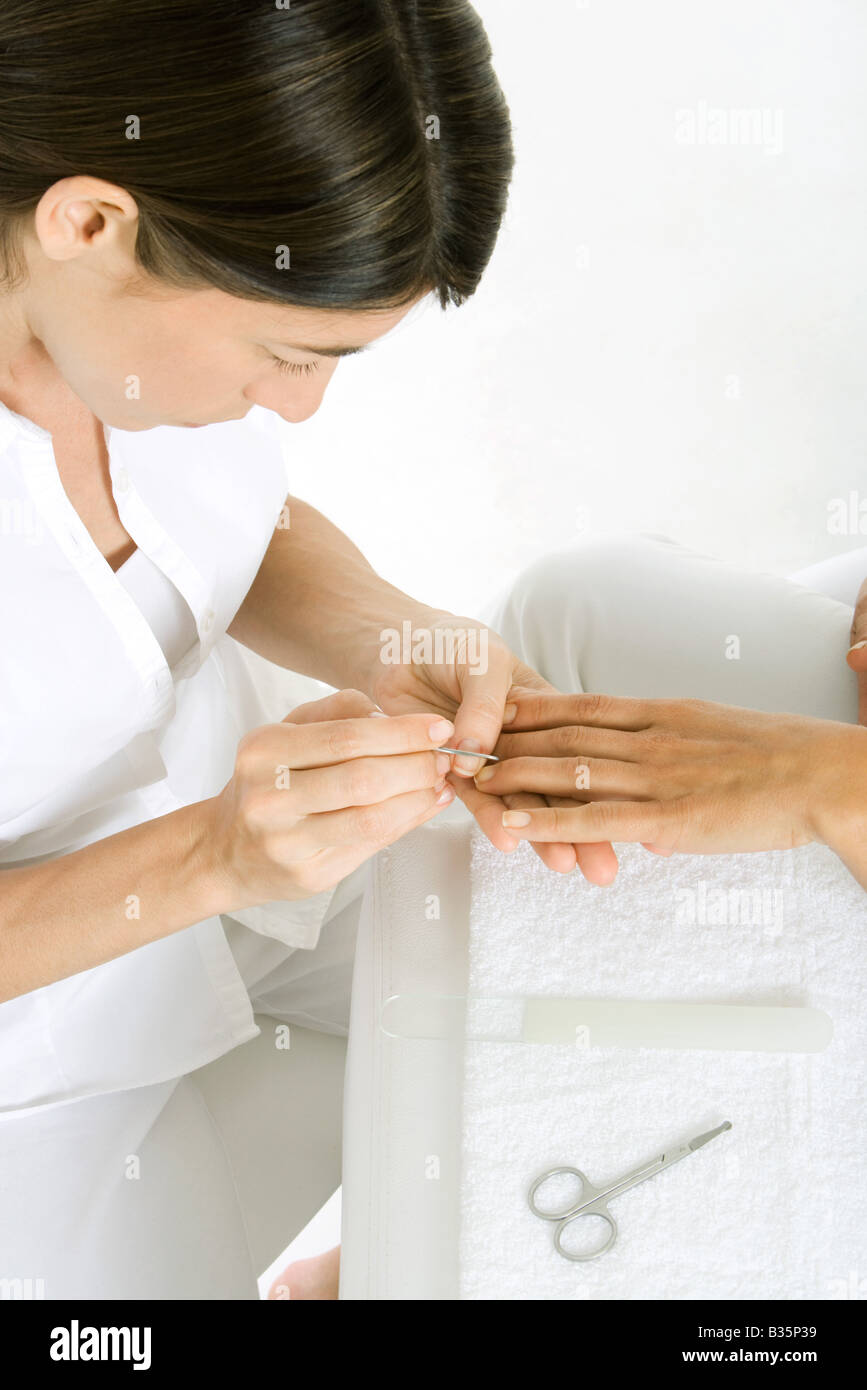 Beautician giving a manicure, cropped view of woman's hand, high angle ...