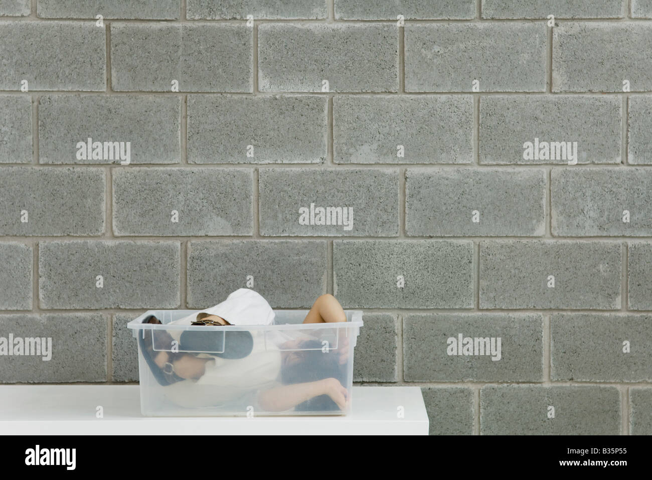 Little boy scrunched up in plastic storage container Stock Photo - Alamy