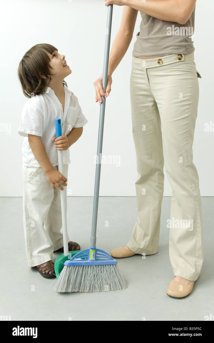 Little boy helping his mother sweep the floor, cropped view Stock Photo ...