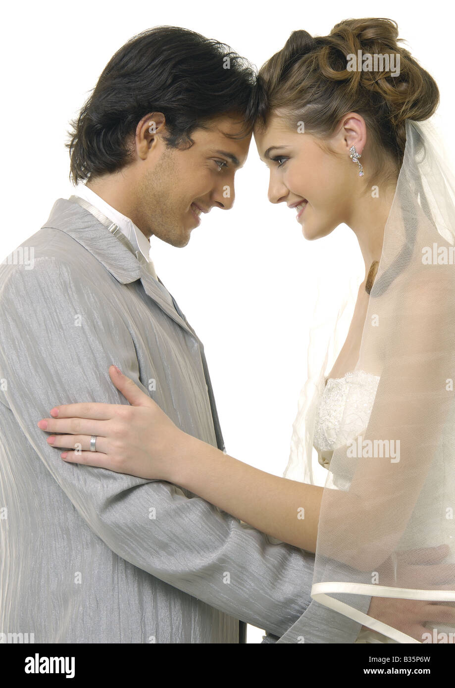 Side profile of a newlywed couple looking at each other and smiling ...