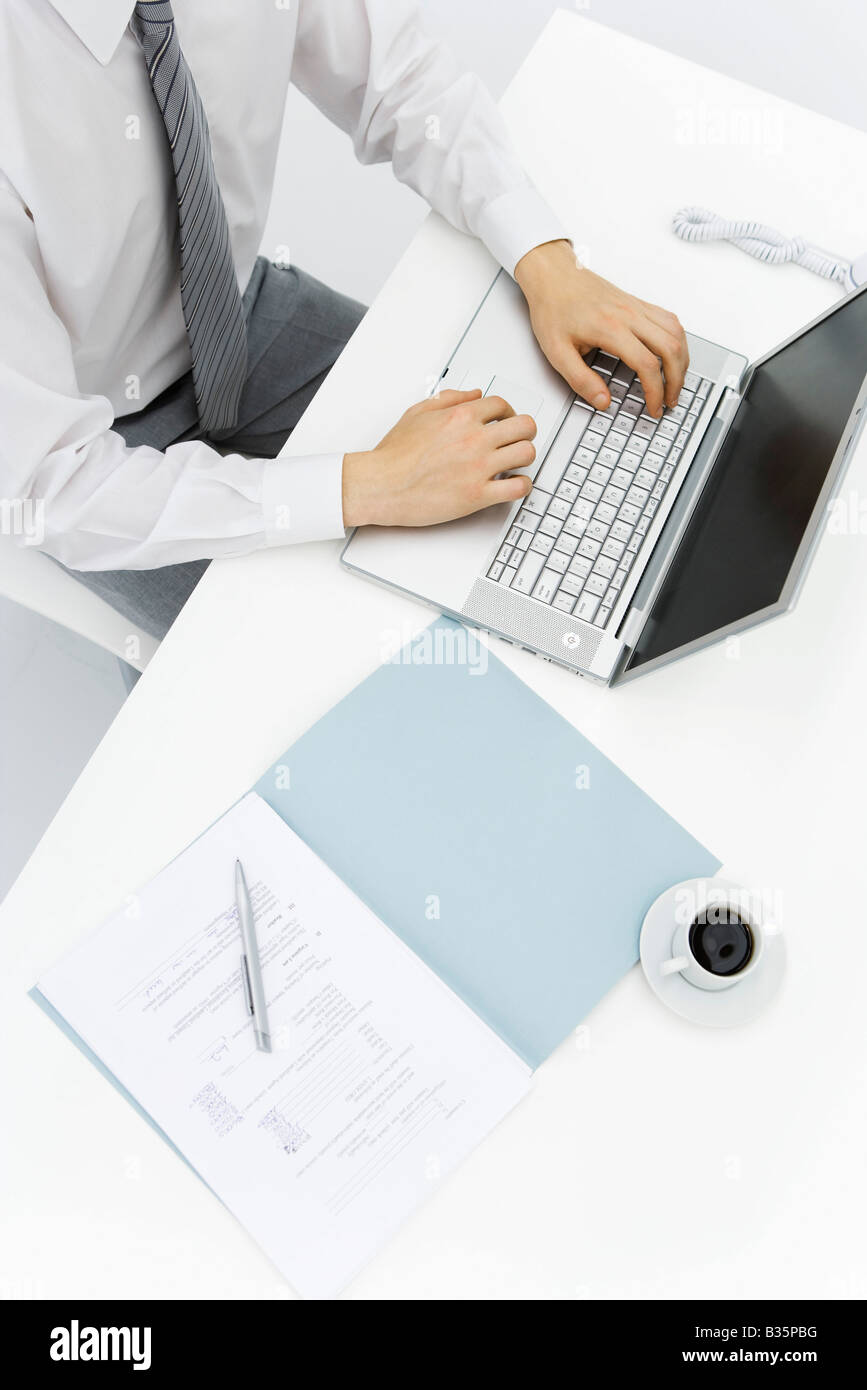 Man using laptop on desk, high angle cropped view Stock Photo - Alamy