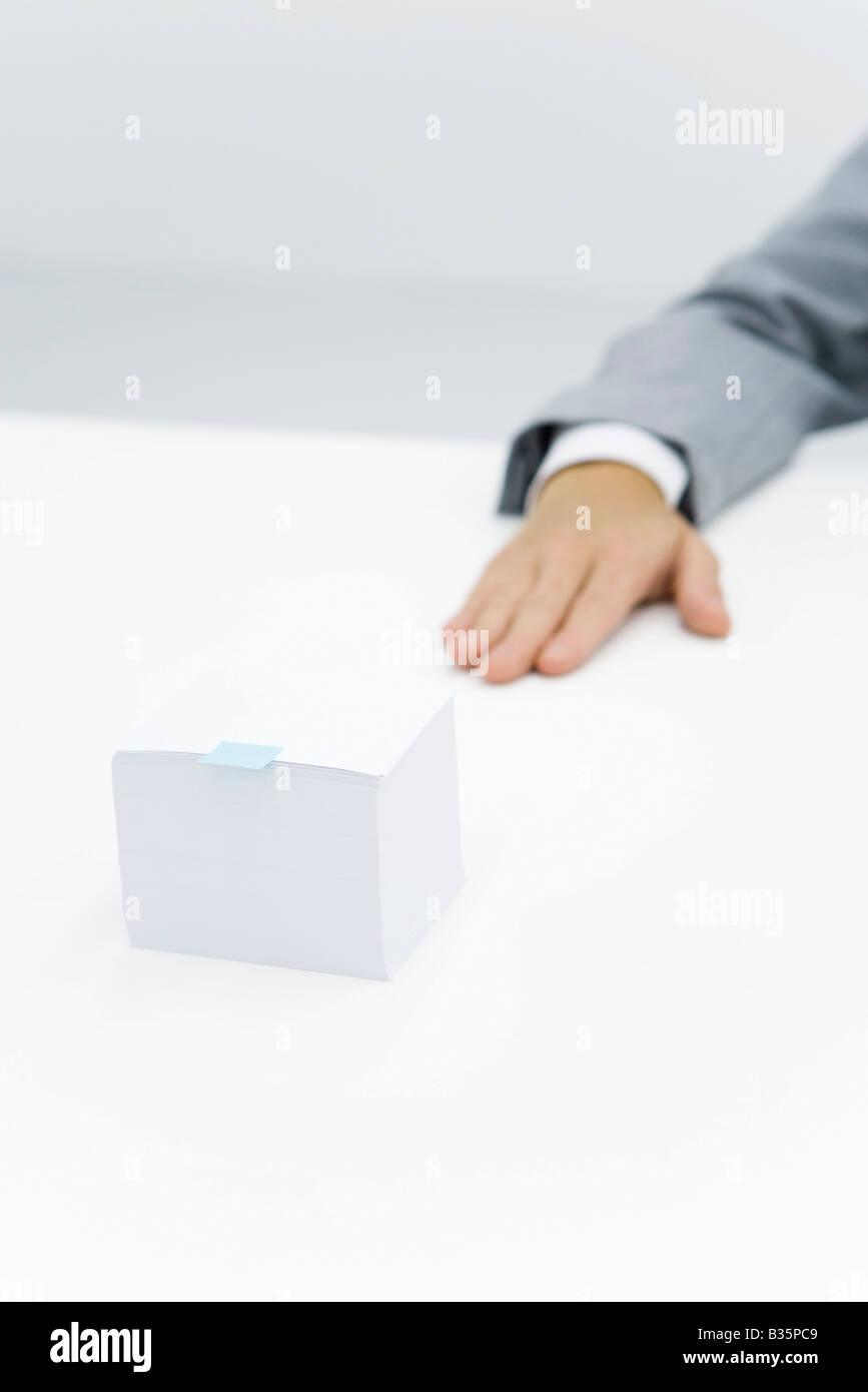 Stack of paper with small adhesive note stuck on it, cropped view of ...