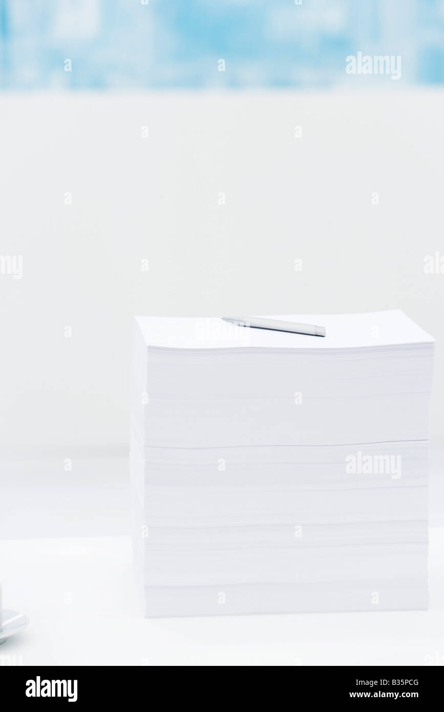 Stack of paper with pen on top of it Stock Photo - Alamy