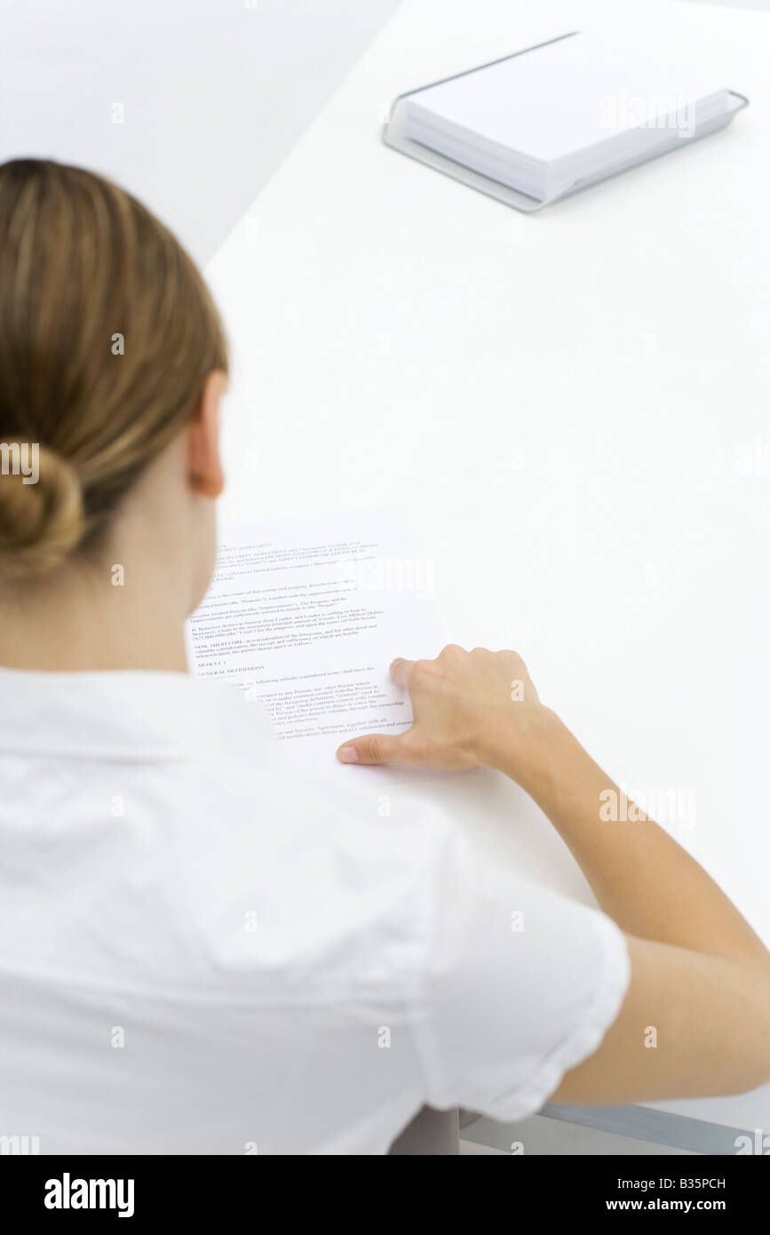 Woman reading document, over the shoulder view Stock Photo - Alamy