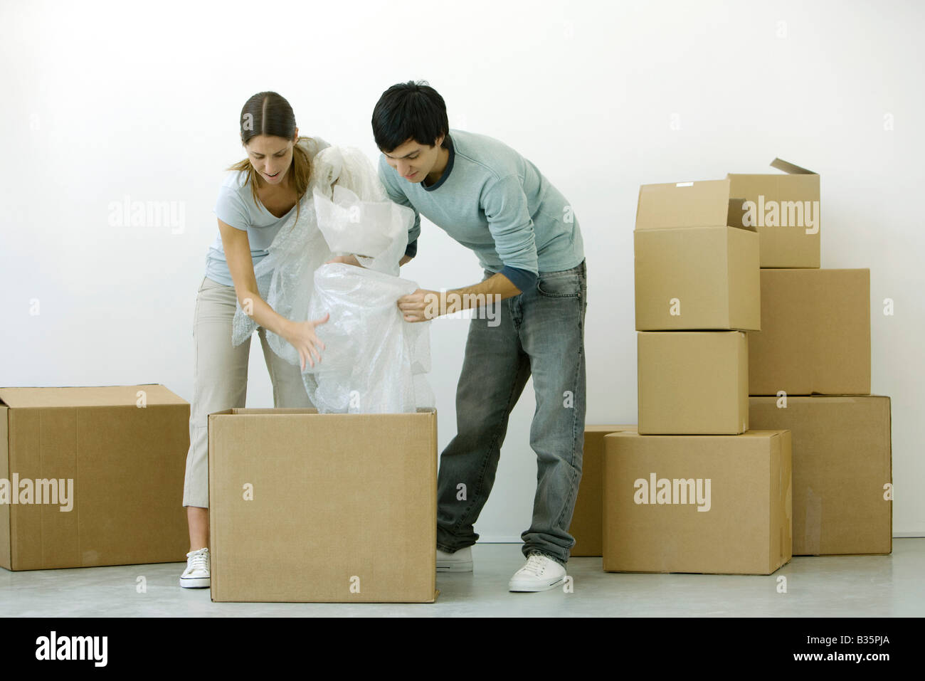 Couple unpacking cardboard boxes together Stock Photo - Alamy