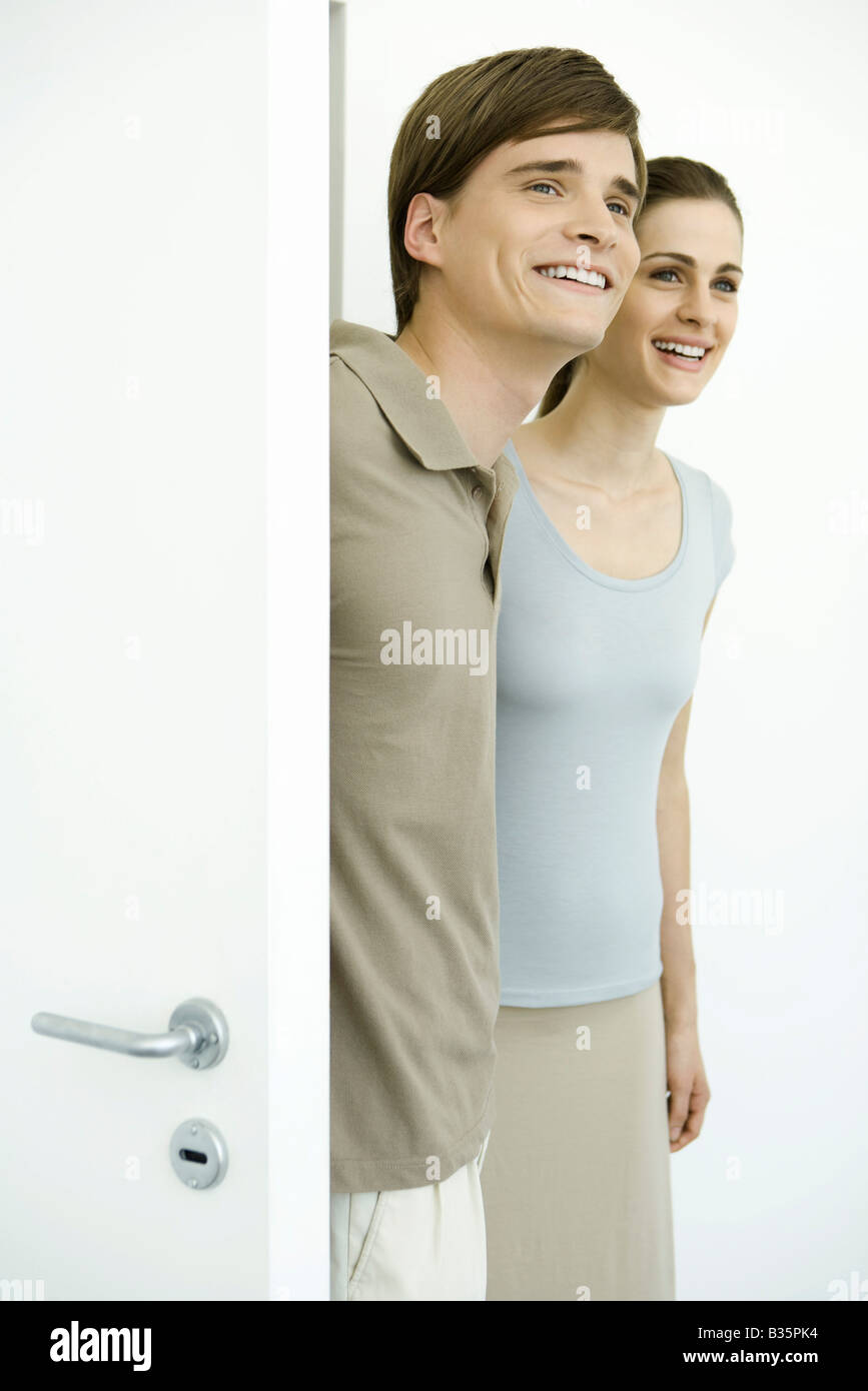 Couple opening door, smiling Stock Photo - Alamy