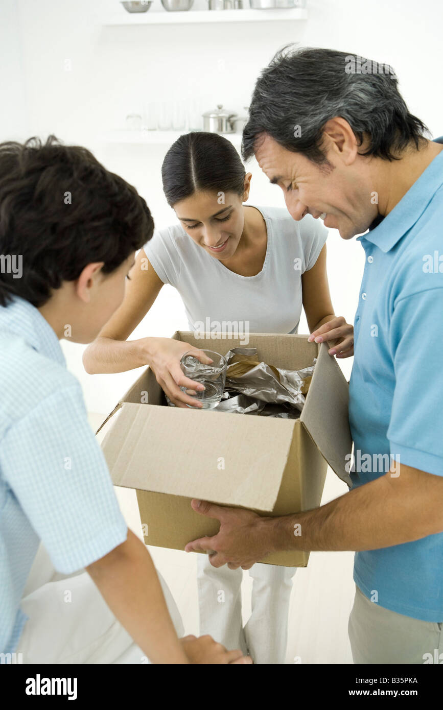 Family unpacking box together Stock Photo - Alamy