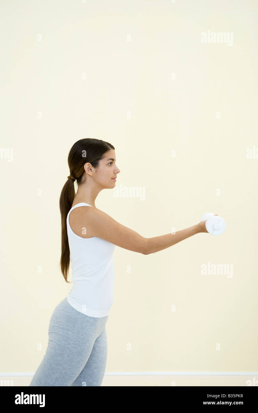 Young woman lifting weights, side view Stock Photo - Alamy