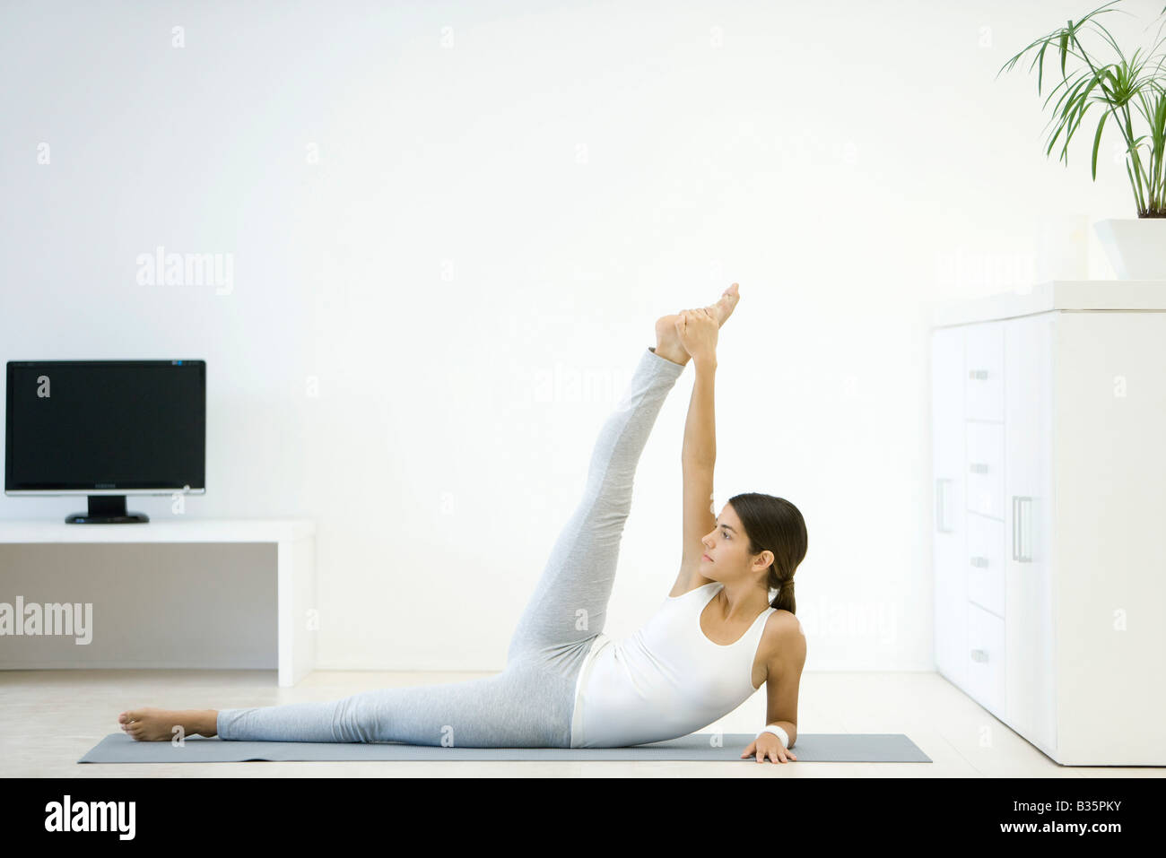 Young woman lying on the ground, stretching legs Stock Photo - Alamy