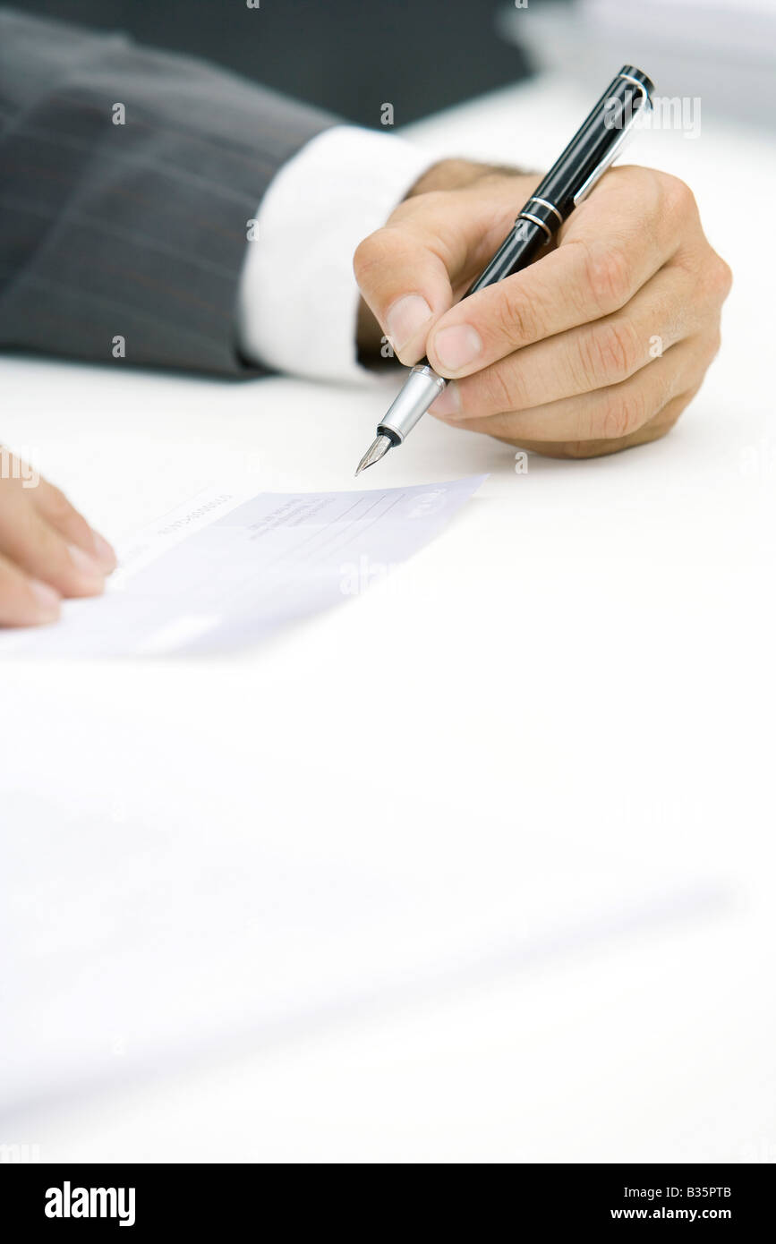 Businessman signing check, cropped view of hand Stock Photo - Alamy
