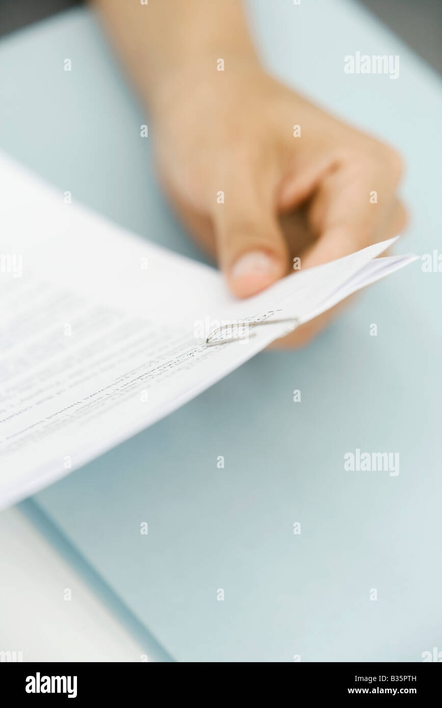 Person reading document, cropped view of hand Stock Photo - Alamy