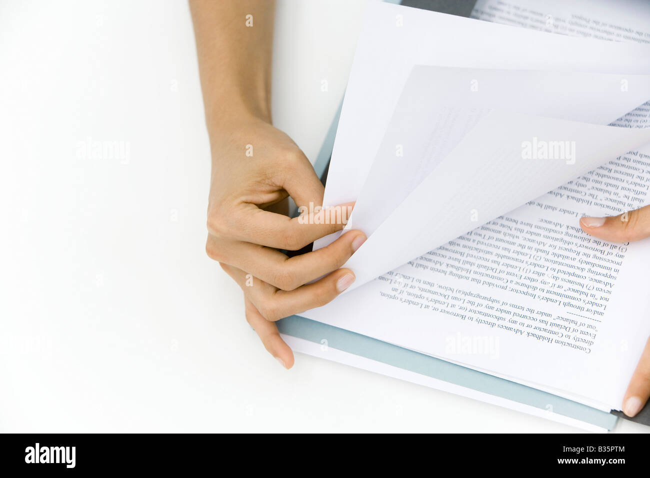 Person thumbing through pages of document, cropped view of hands Stock ...