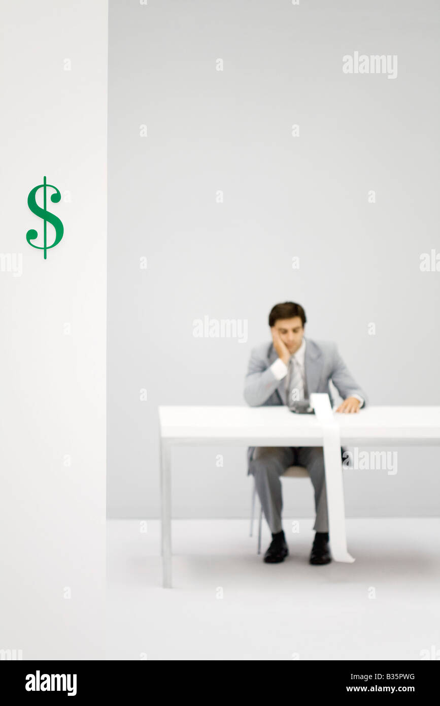 Accountant using adding machine, holding head, dollar sign in ...