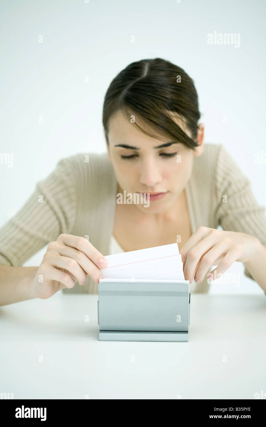 Young woman looking through box of index cards Stock Photo - Alamy