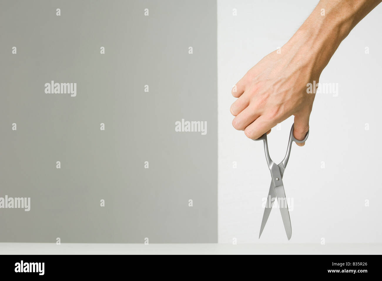 Hand holding pair of scissors open, pointed down, cropped view Stock ...