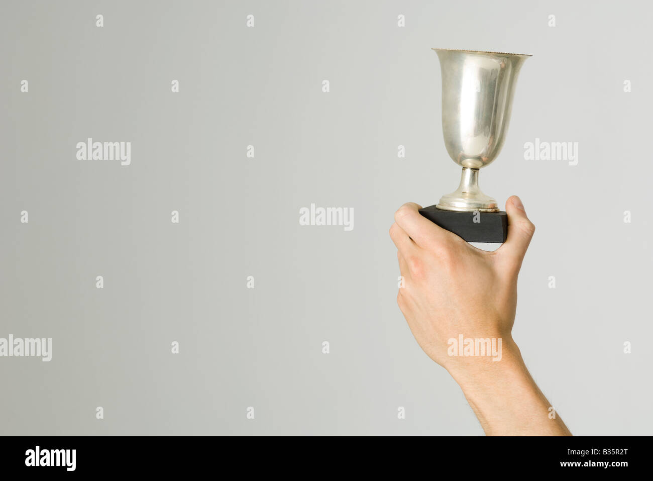 Hand holding up trophy, cropped view Stock Photo - Alamy