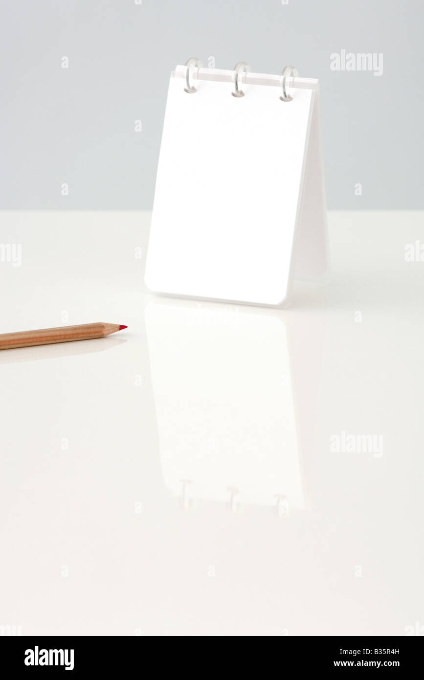 Notepad upright on table, cropped view of pencil nearby Stock Photo - Alamy