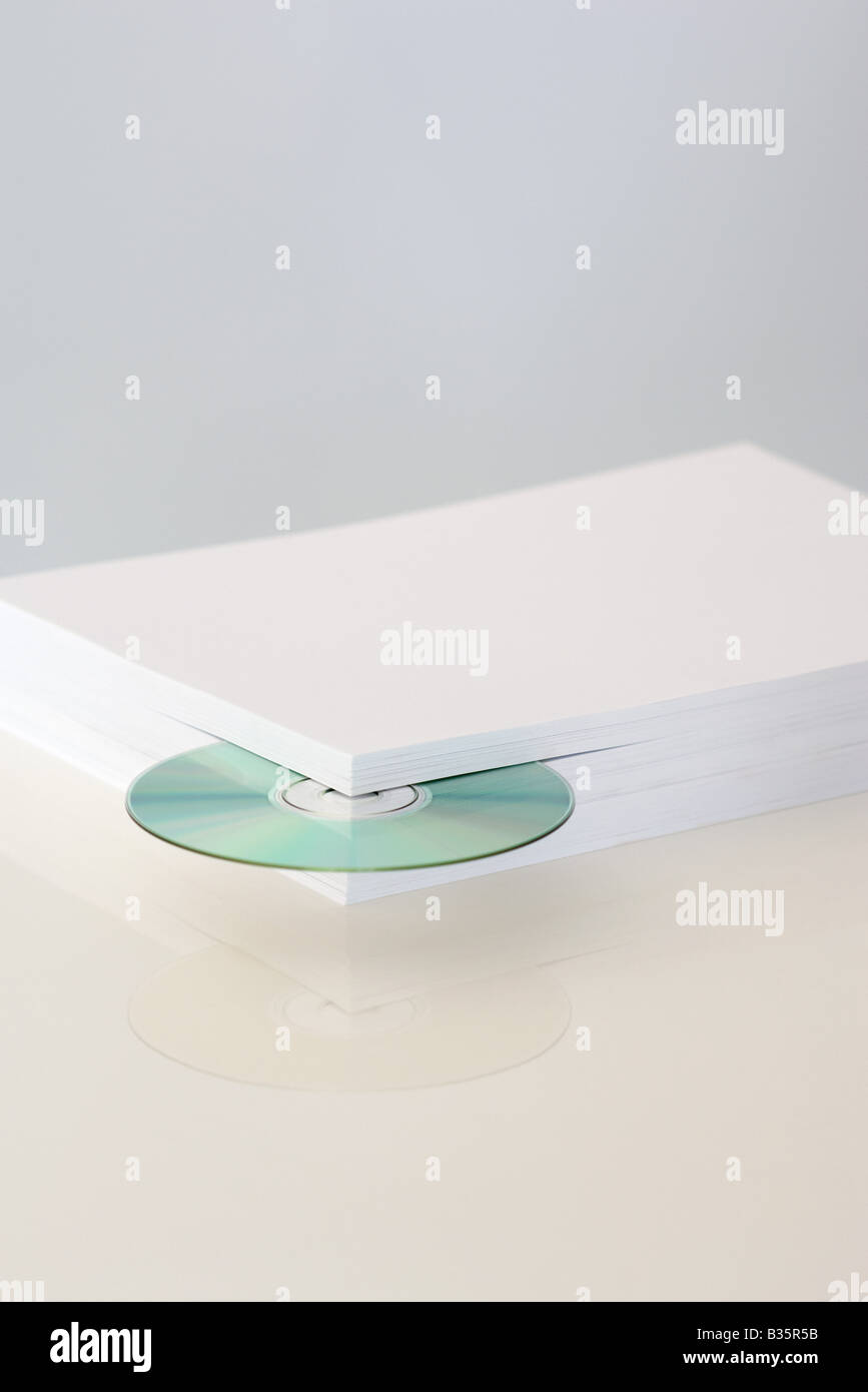 Stack of paper with CD emerging from the corner Stock Photo - Alamy