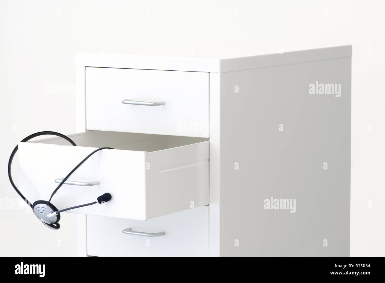 Headset hanging from an open drawer of a filing cabinet Stock Photo - Alamy