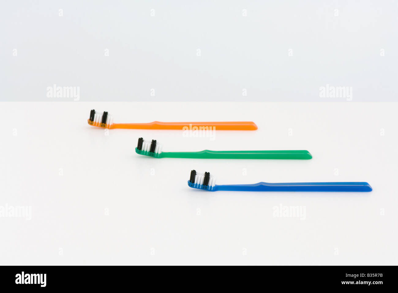 Three toothbrushes, staggered and colorful Stock Photo - Alamy