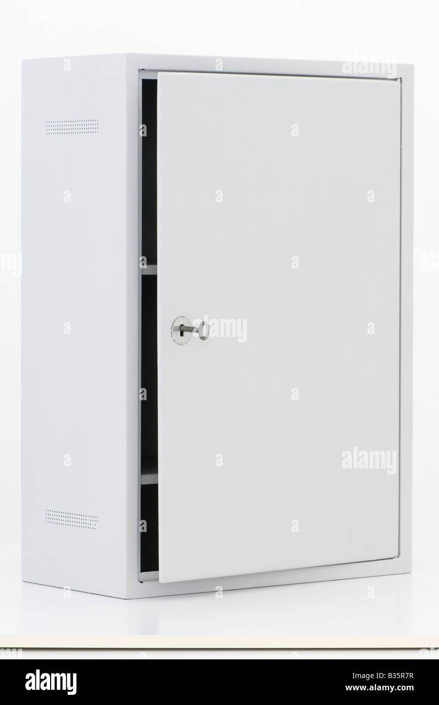 Cabinet with door slightly ajar, key in lock Stock Photo - Alamy