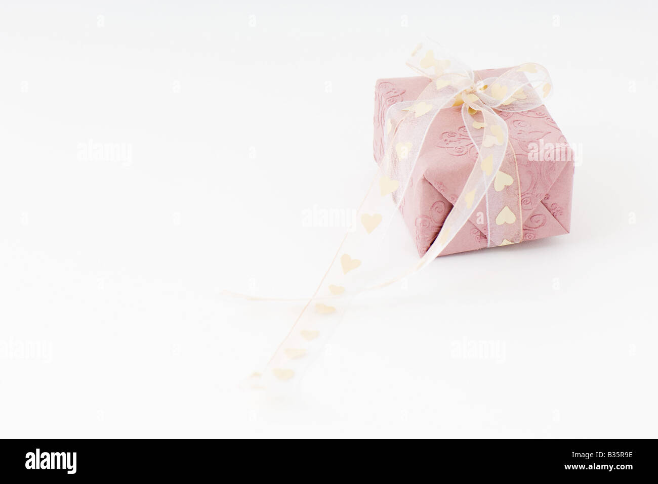 Wrapped gift with heart ribbon Stock Photo - Alamy