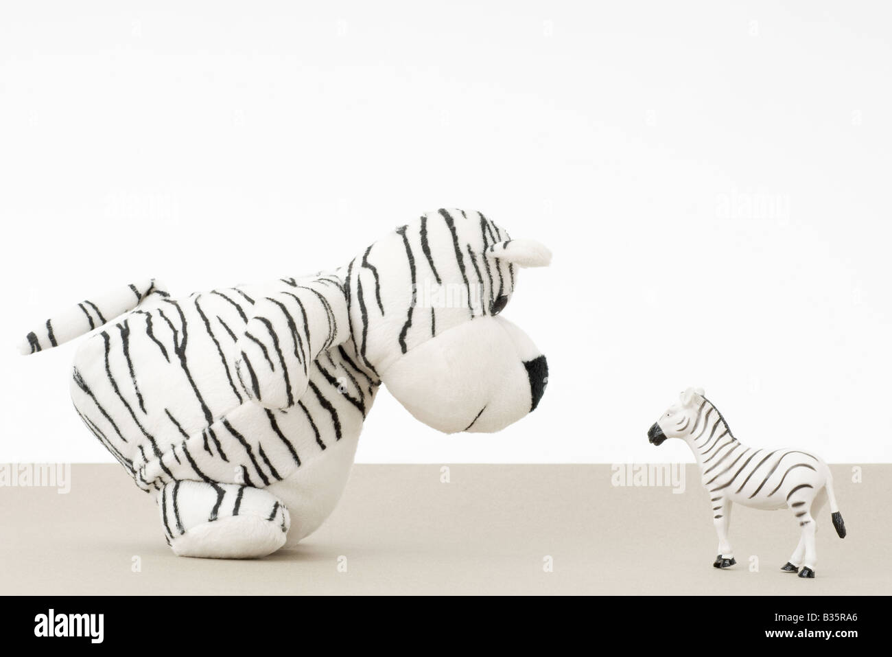 Toy tiger facing toy zebra, side view Stock Photo - Alamy