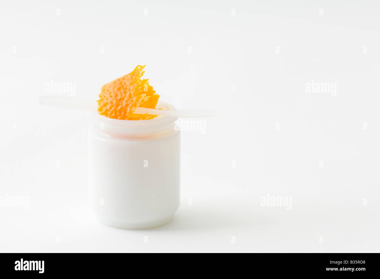 Orange zest in small jar, tiny plastic spatula jutting out Stock Photo ...