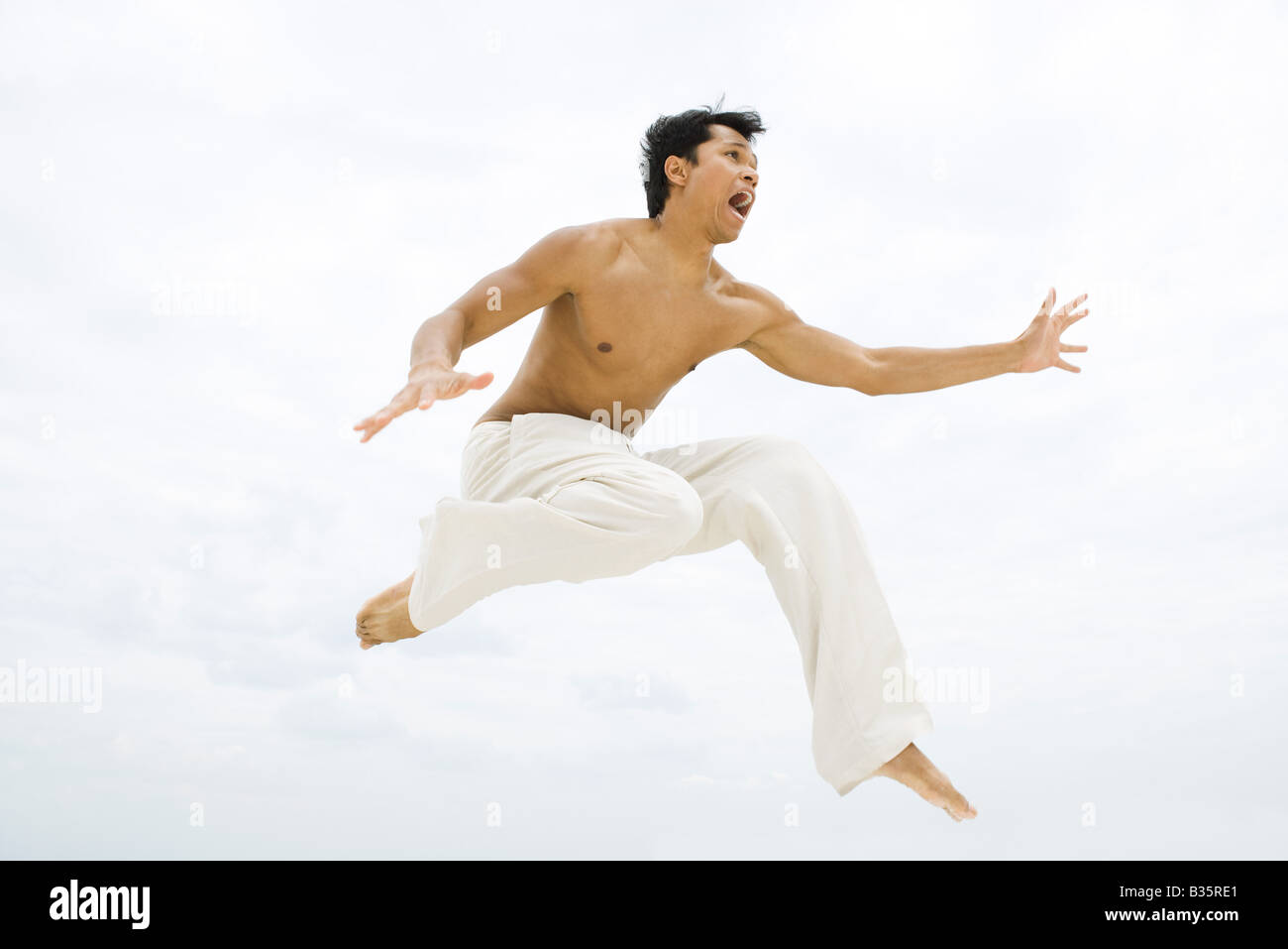 Man leaping in the air, side view Stock Photo - Alamy