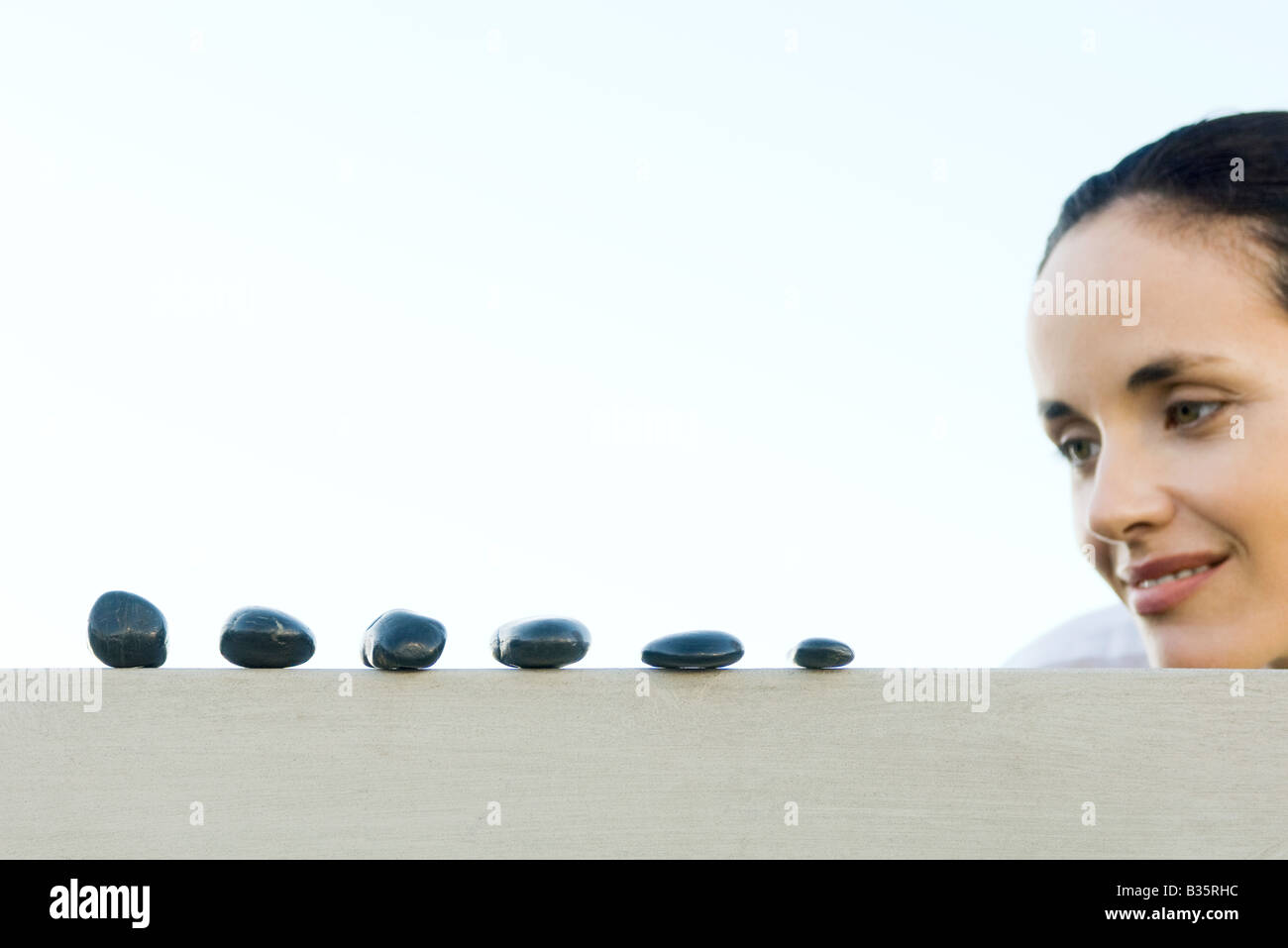 Woman looking at line of stones Stock Photo - Alamy