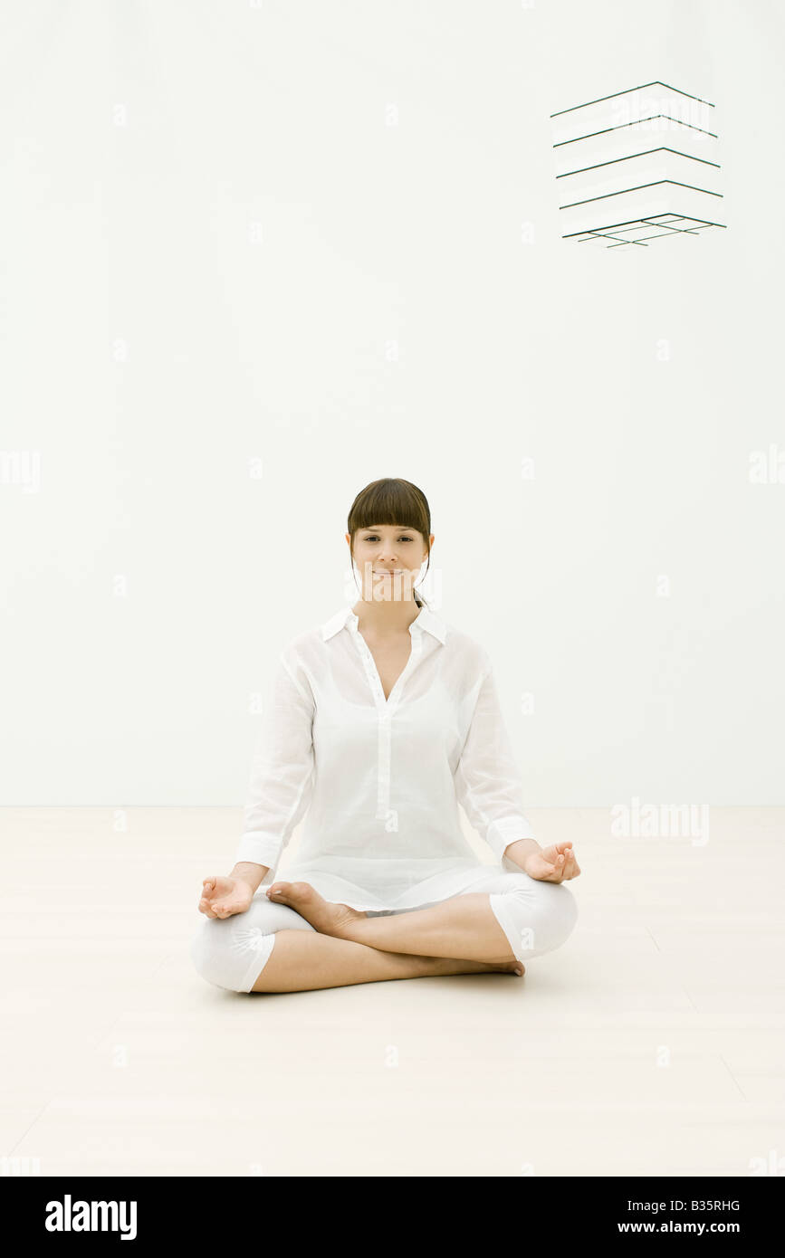 Woman sitting in lotus position, smiling at camera Stock Photo - Alamy