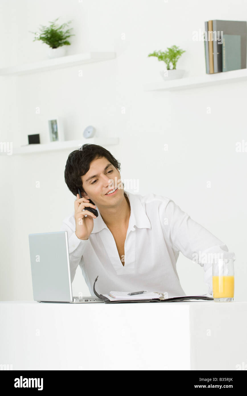 Man uses phone sitting desk hi-res stock photography and images - Alamy