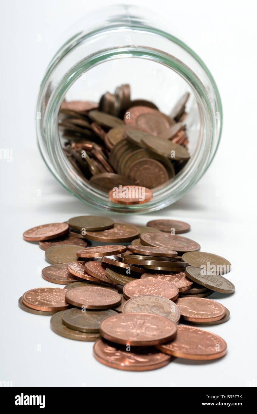 Glass jar spilling out copper coins Stock Photo - Alamy
