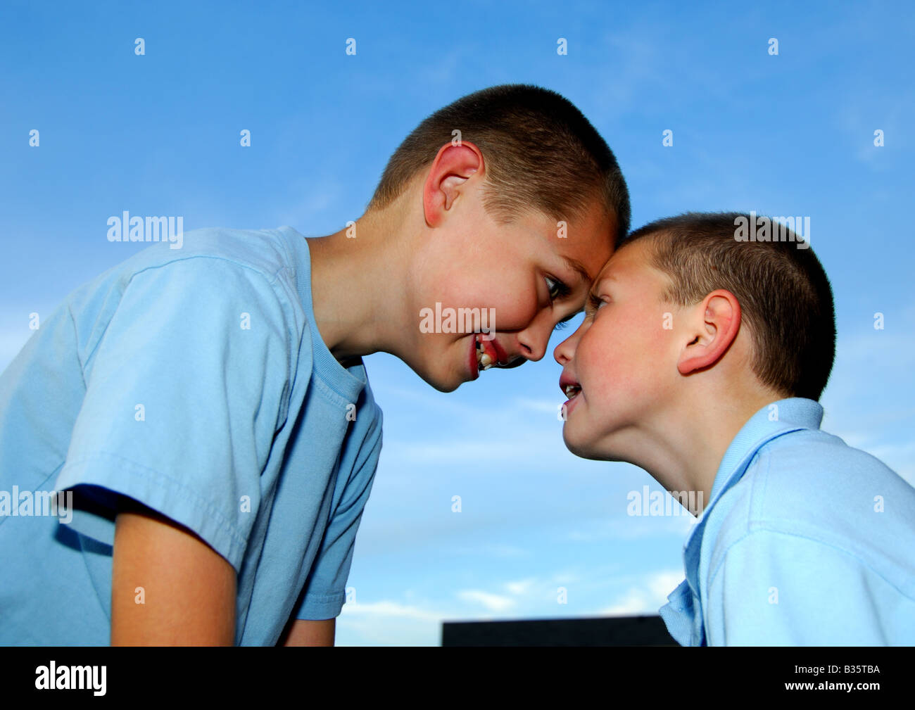 Side profile of two boys standing face to face and smiling Stock Photo ...