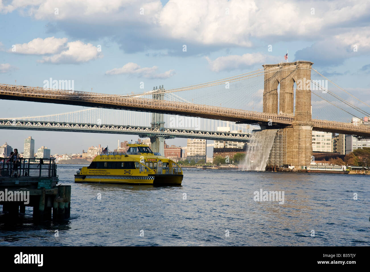 New York water taxi with brooklyn Bridge and Ny waterfall in background ...